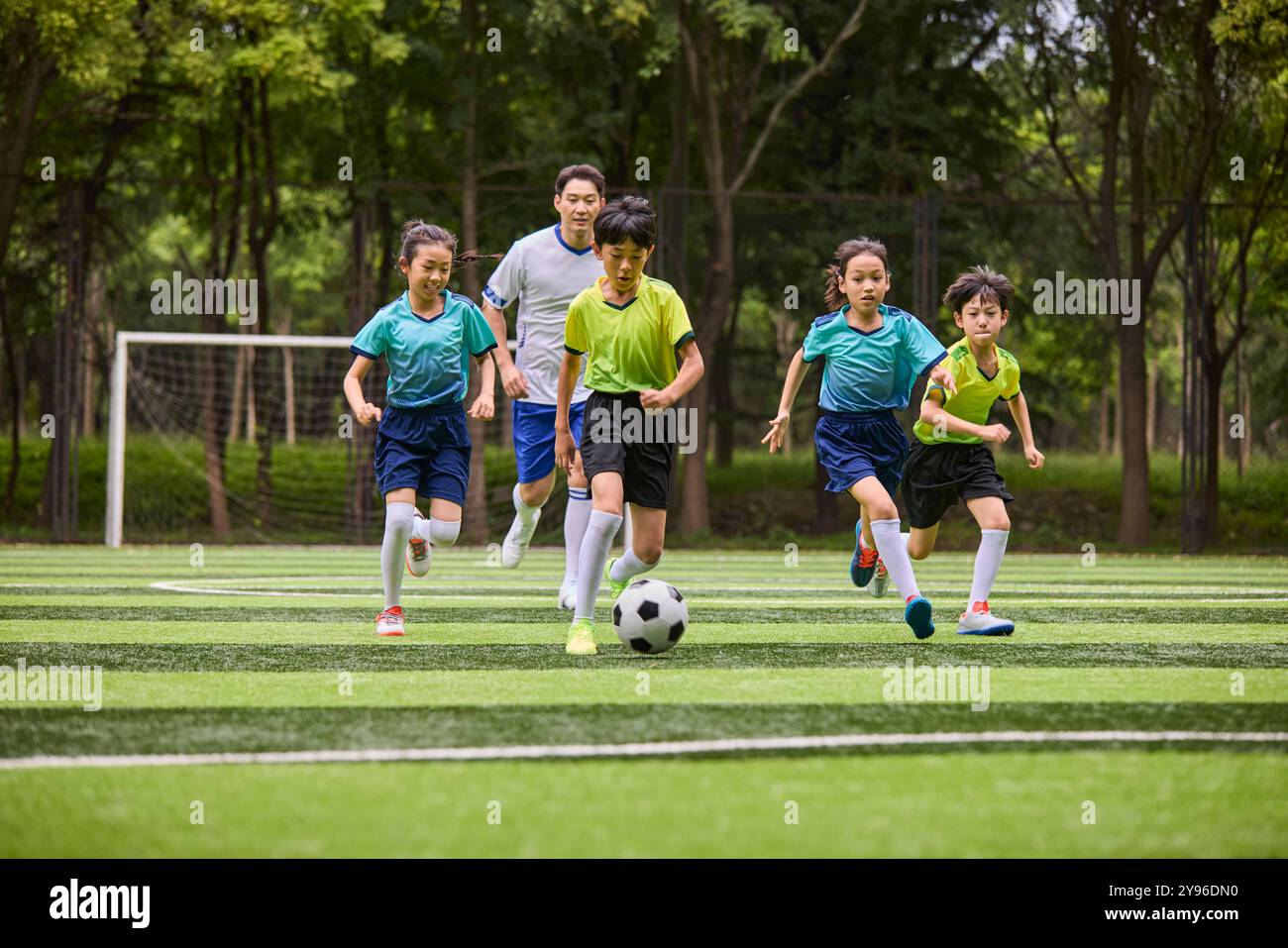 Chinese Kids Playing Football on Soccer Field Stock Photo - Alamy