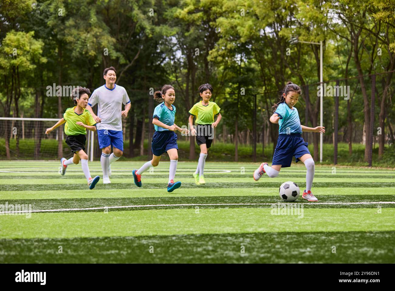 Chinese Kids Playing Football on Soccer Field Stock Photo - Alamy