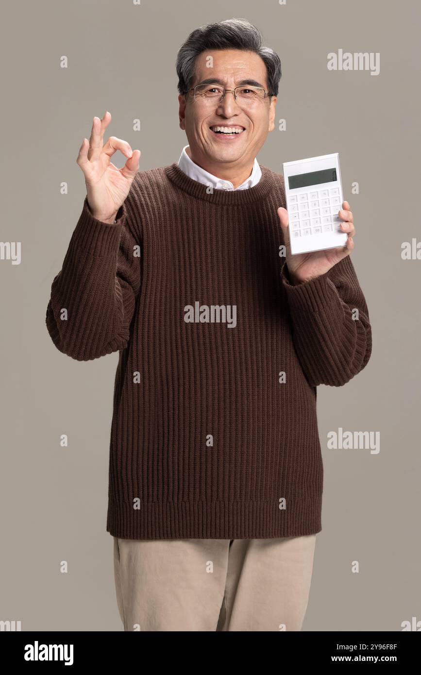 Senior man presenting a calculator Stock Photo - Alamy