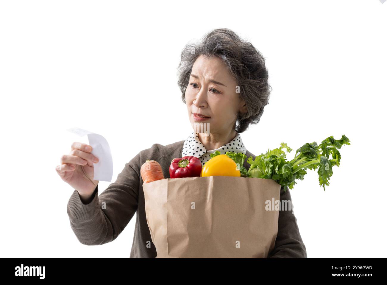 Senior woman holding groceries and receipt Stock Photo - Alamy