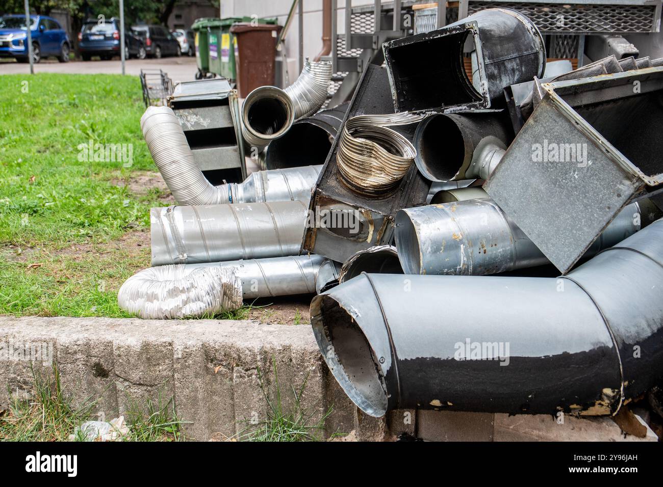 A pile of various tin pipes and fittings on the ground outdoors Stock ...