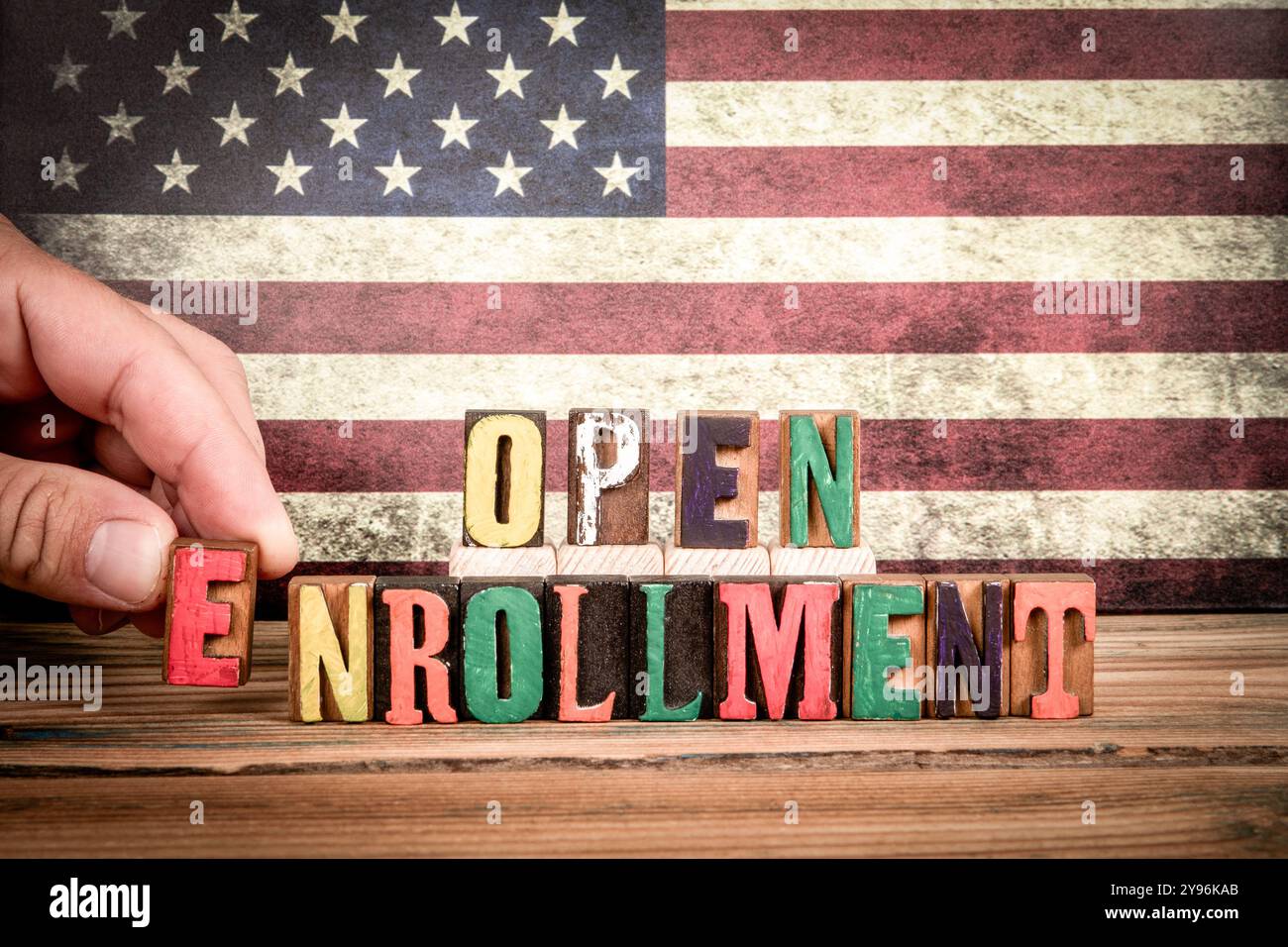 OPEN ENROLLMENT. Colorful letters of the alphabet on a wooden texture ...