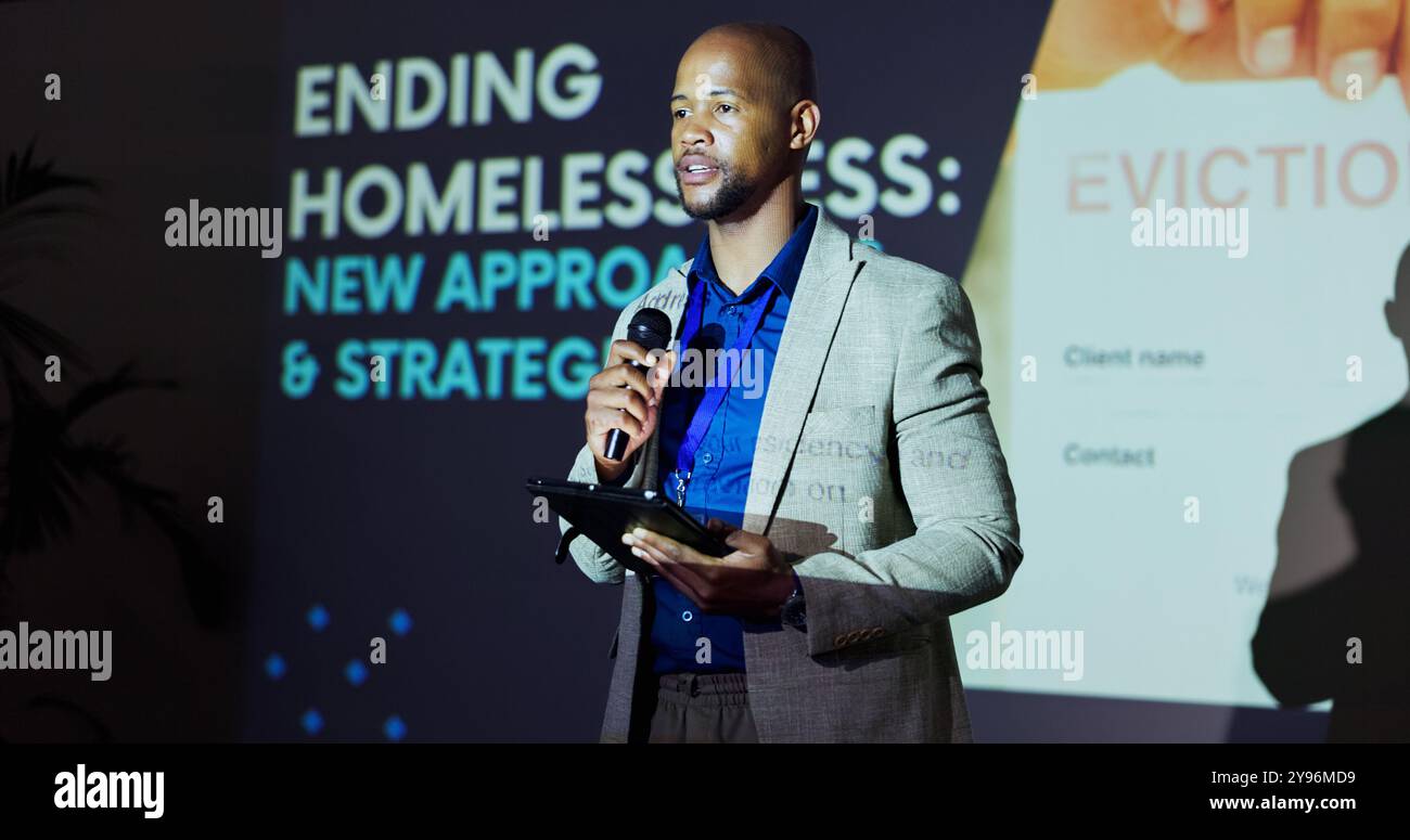 African man, presentation and stage at convention for homeless crisis ...
