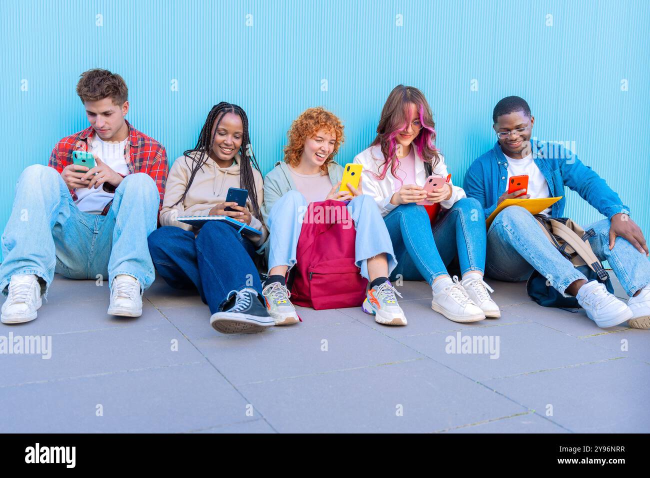 Diverse Young People Sitting Outdoors Using Smartphones Stock Photo Alamy