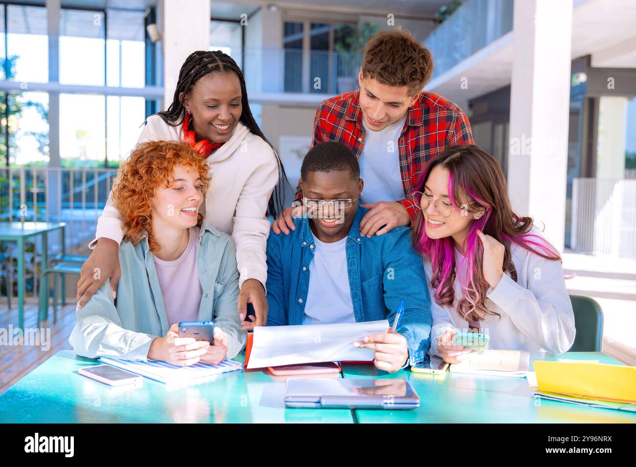 Happy diverse group of students studying in the library Stock Photo - Alamy