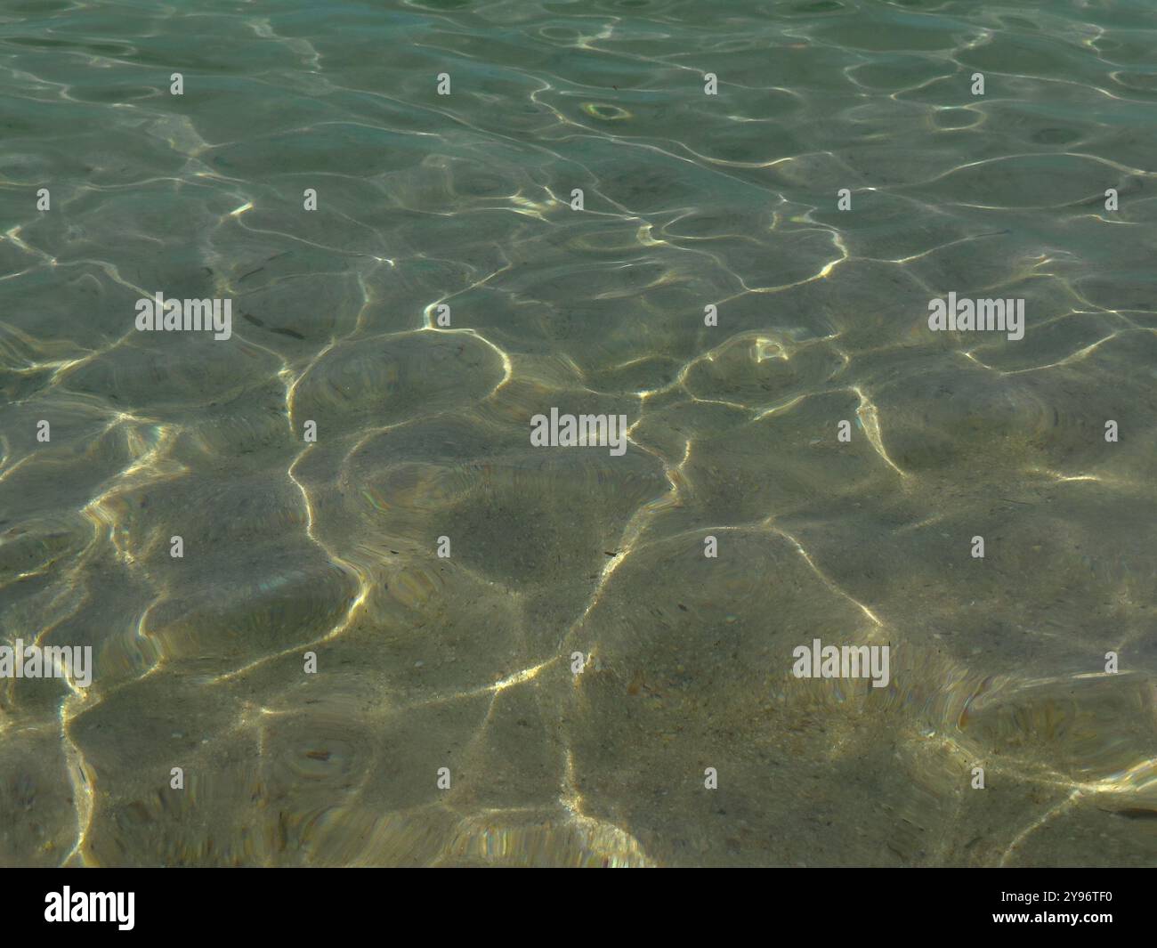 Crystal clear sea water through which you can see the bottom. Sunlight ...