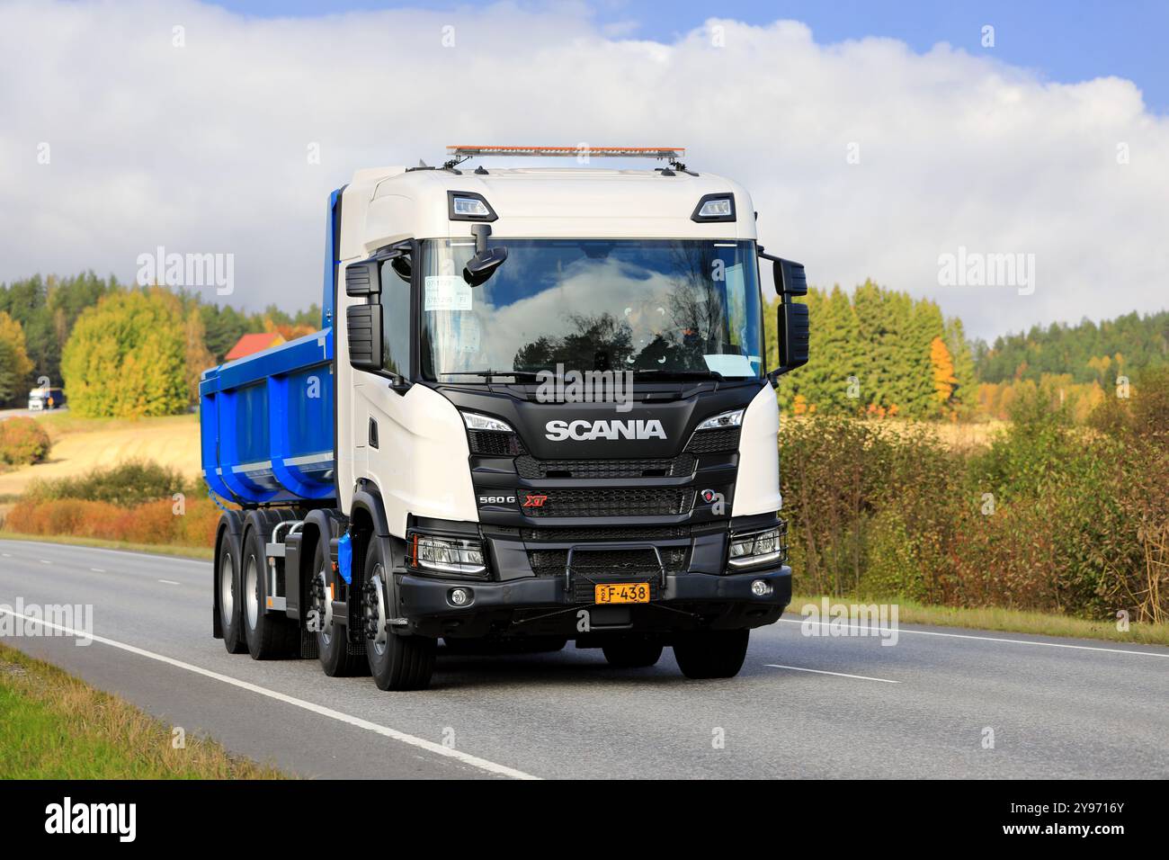 New, white Scania 560G XT tipper truck at speed on highway on a day of ...