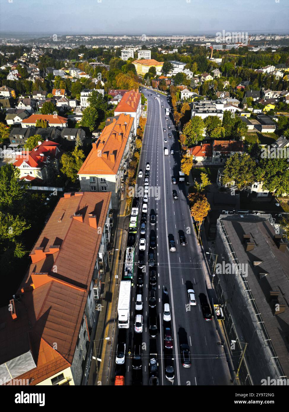 Aerial view of a city street with moving cars and buildings frome above ...
