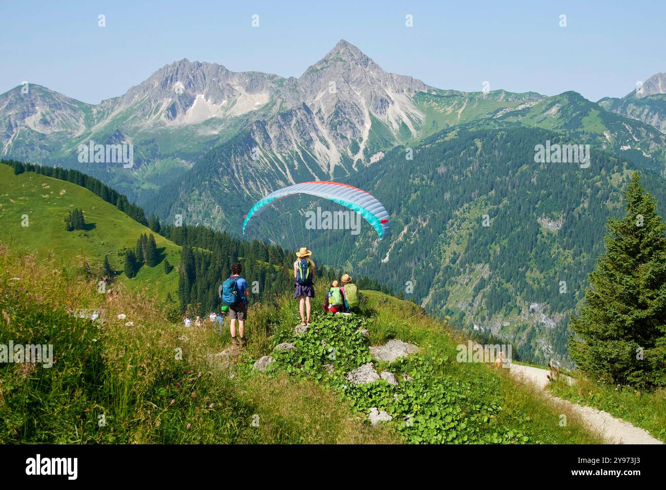 Hiker watching Paraglider flying at Neunerköpfle mountain and ski arena ...