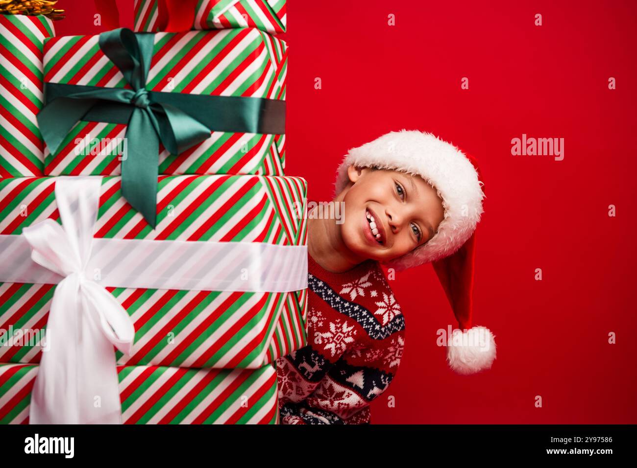 Photo portrait of cute little boy hide behind present pile celebrate ...