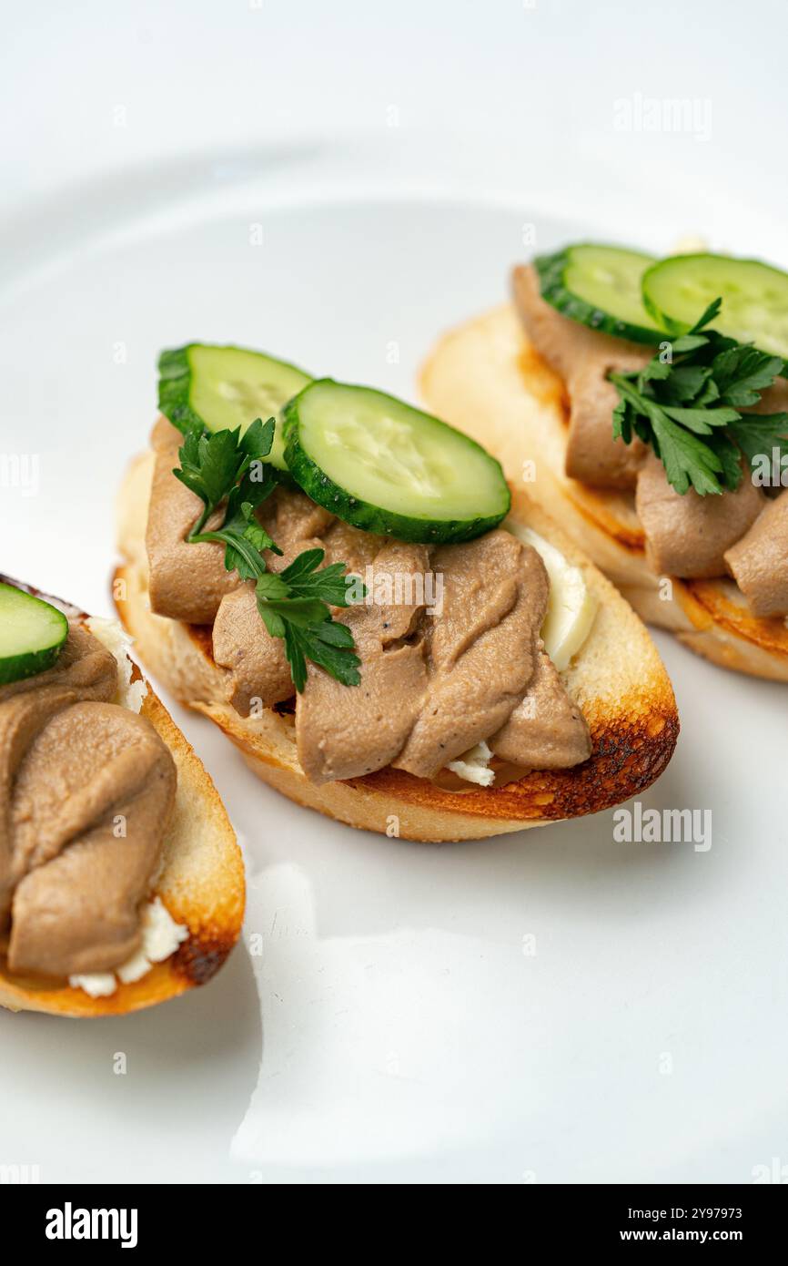 Savory canapes topped with creamy spread and cucumber slices served on ...