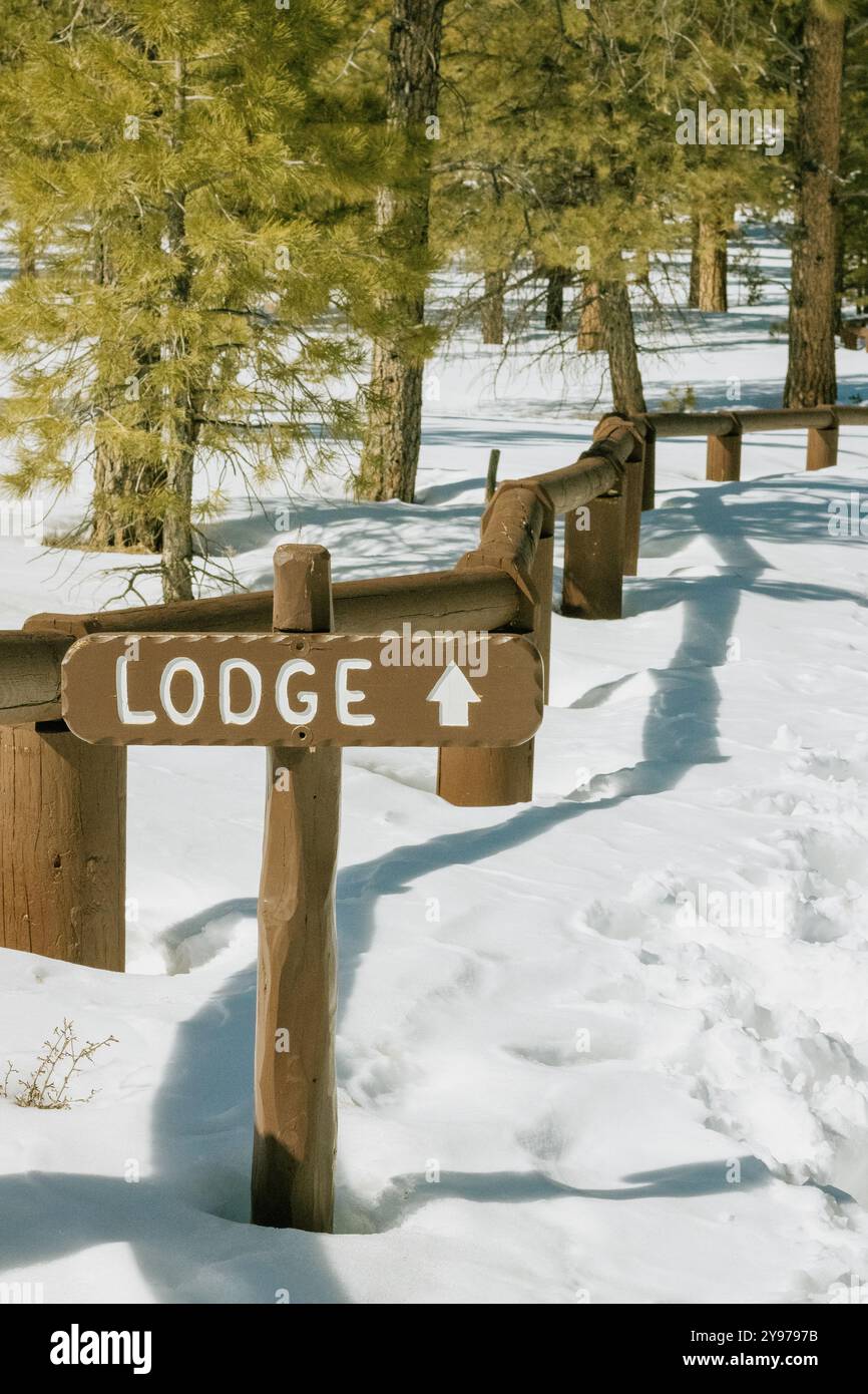 A sign indicating lodge up ahead with a snowy pathway behind it Stock ...