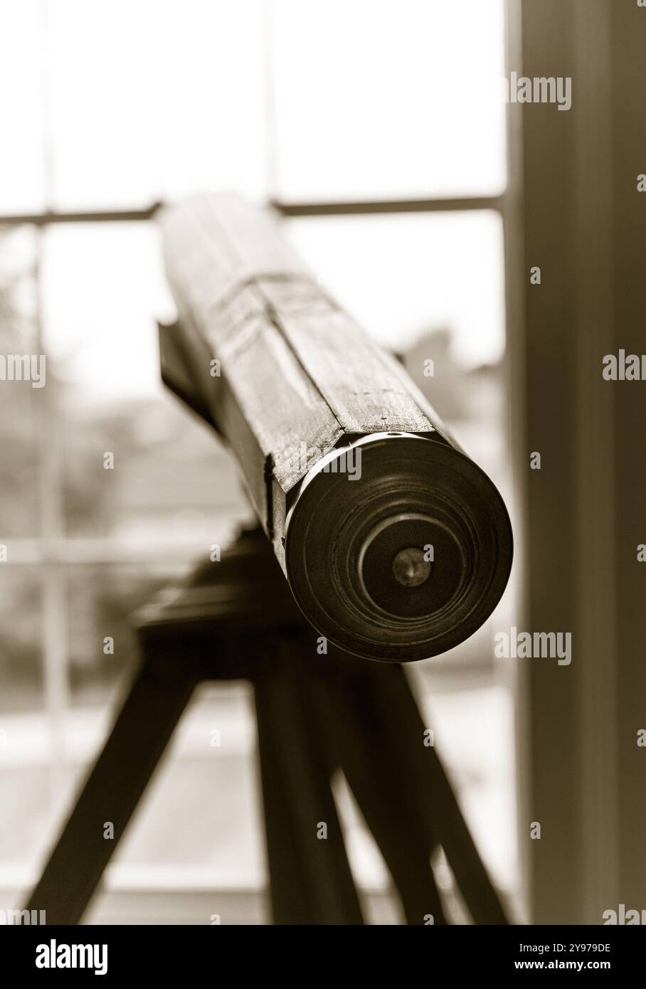 A vintage telescope looking out of the window in an English country ...
