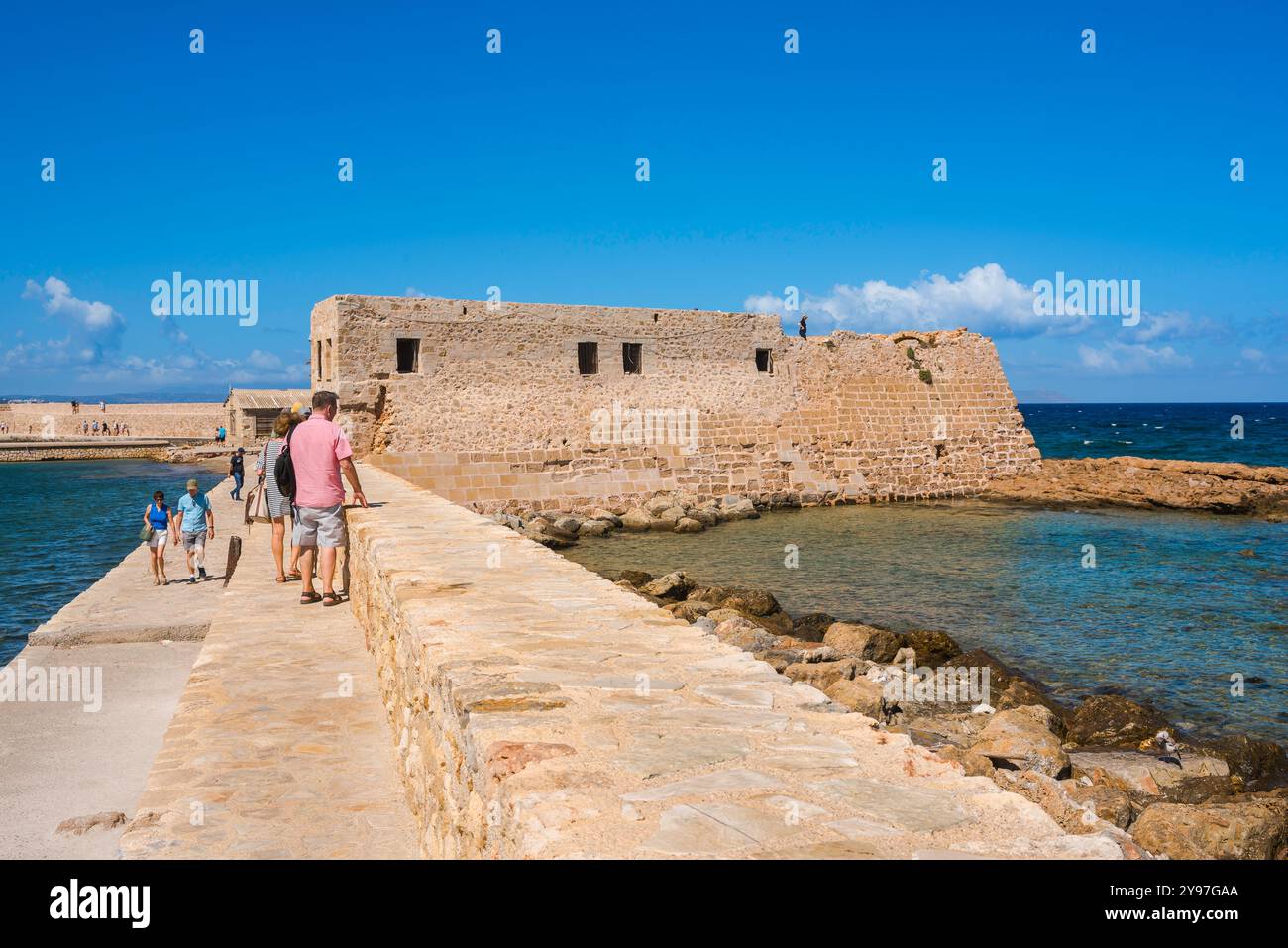 City sea wall Chania, view of tourists walking on the historic sea wall ...