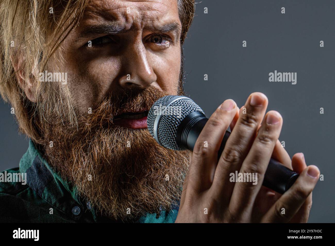 Karaoke concept. Hipster man with beard singing a song with a ...