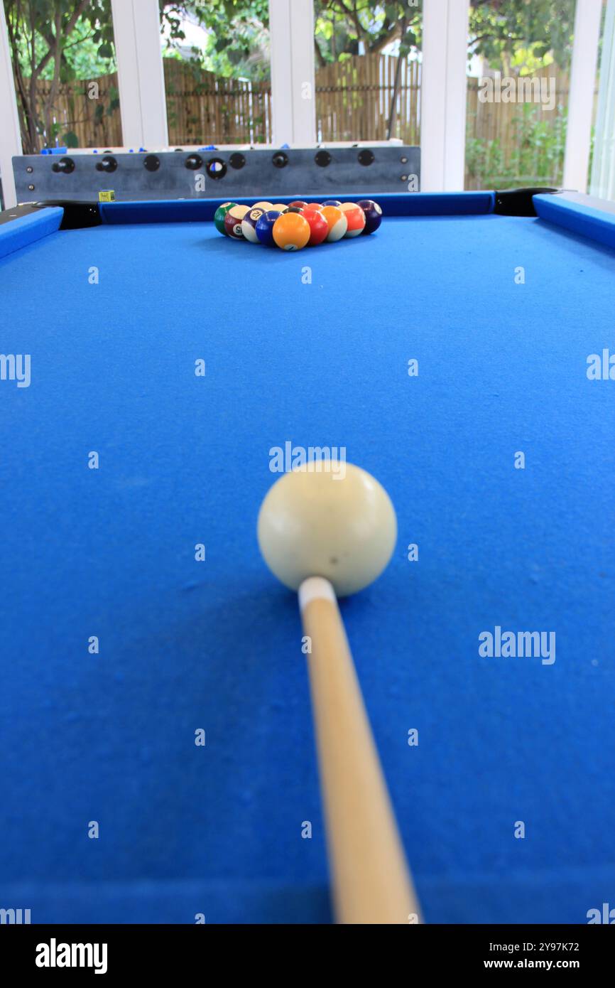Billiard balls with numbers on them on a blue pool table in action of ...
