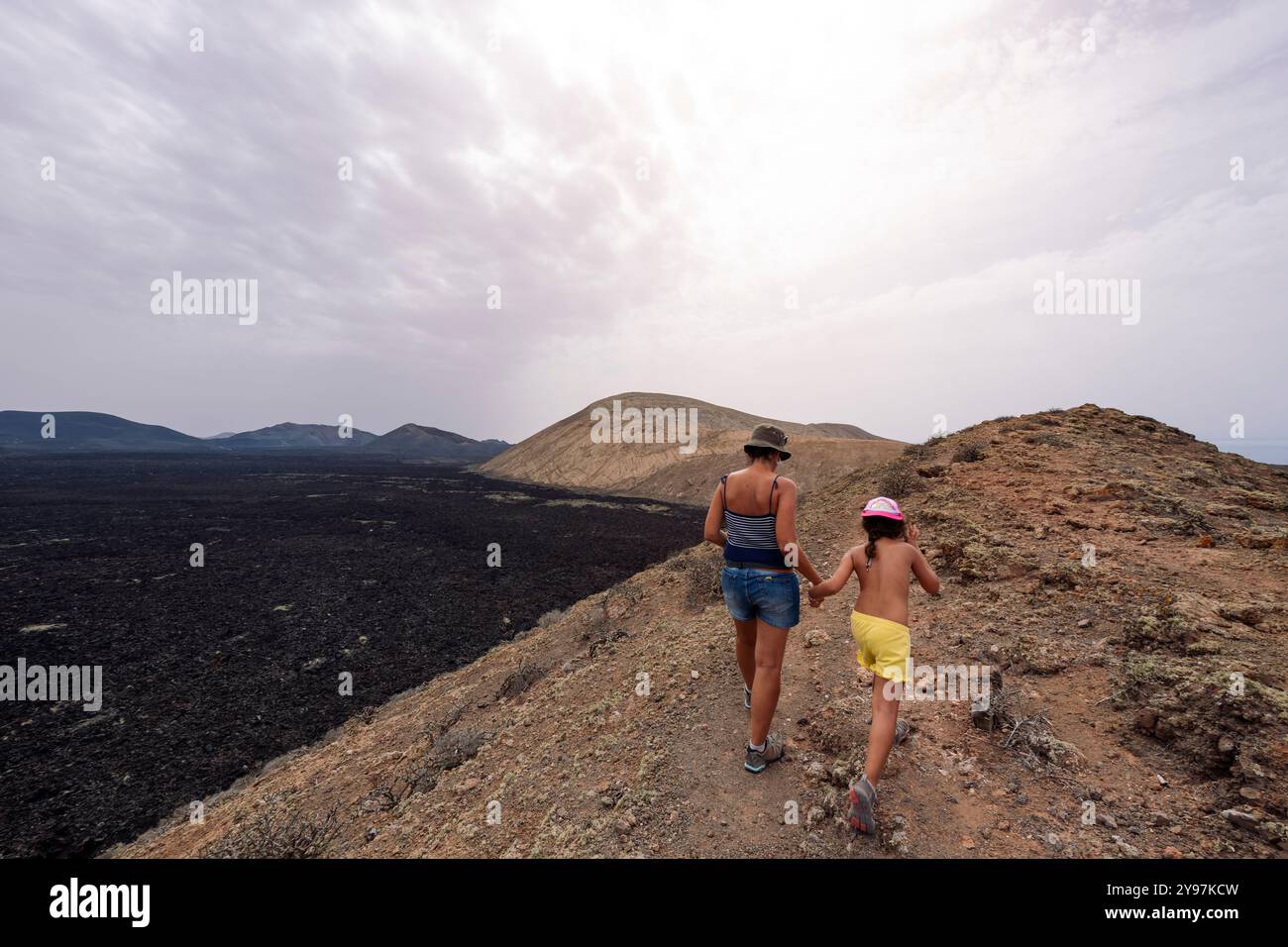 mom with girl strolling by trail in volcano crater Stock Photo - Alamy