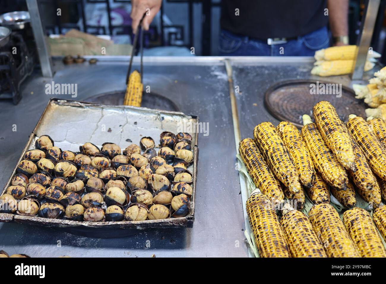 Roasted street chestnuts and corn at a street stall. selling fried corn ...