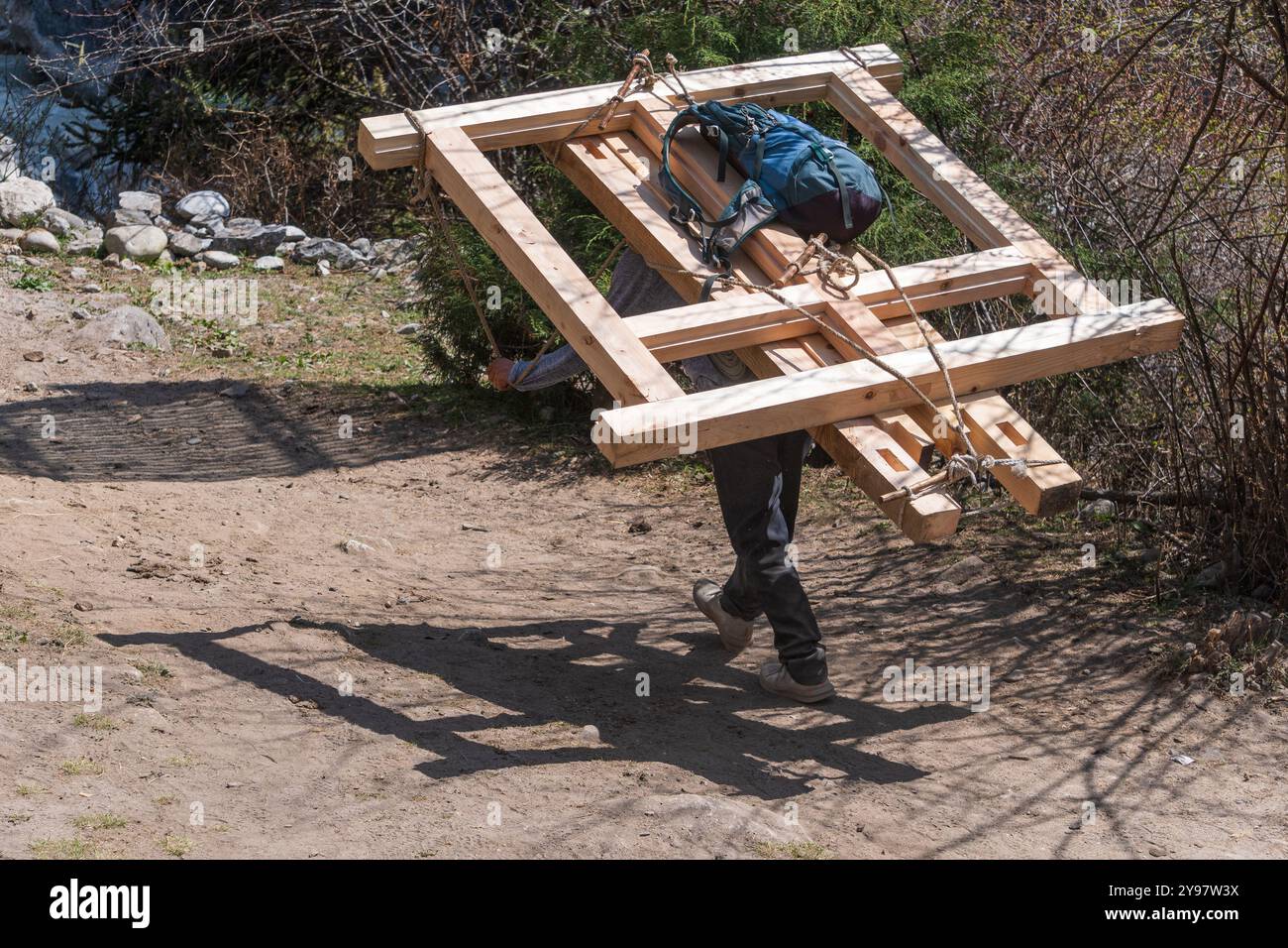 A man carrying a wooden window frame on his back in the Himalayas ...