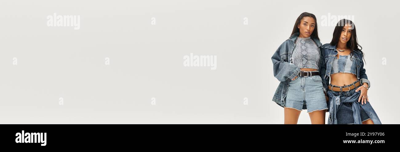 Two confident young women in trendy denim stand side by side, ready for ...