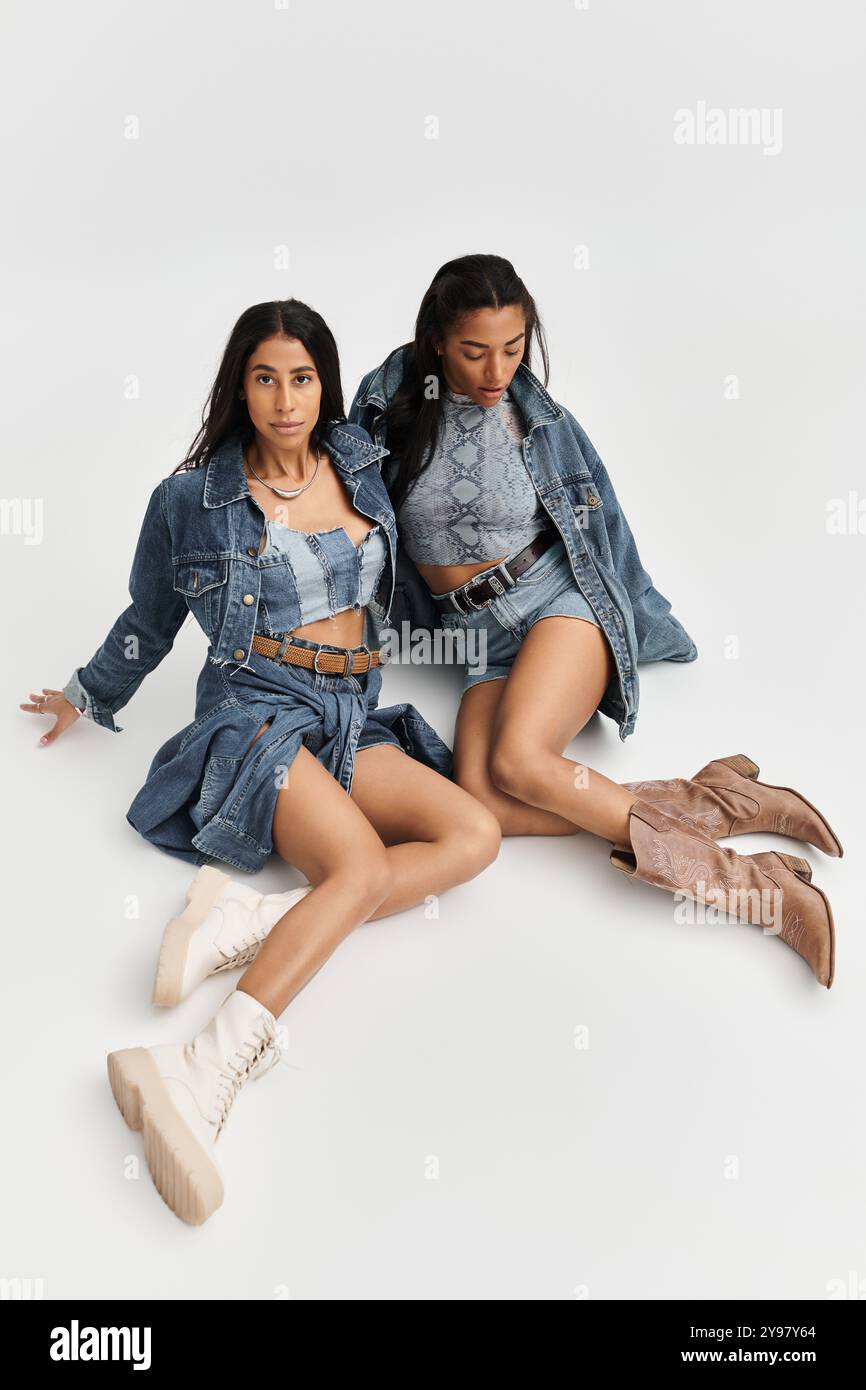 Two young women in fashionable denim attire pose creatively while ...
