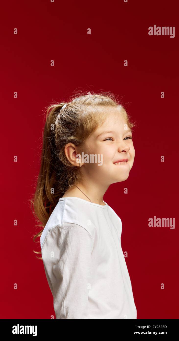 Smiling with scrunched nose, girl gives cheeky grin, making her look ...