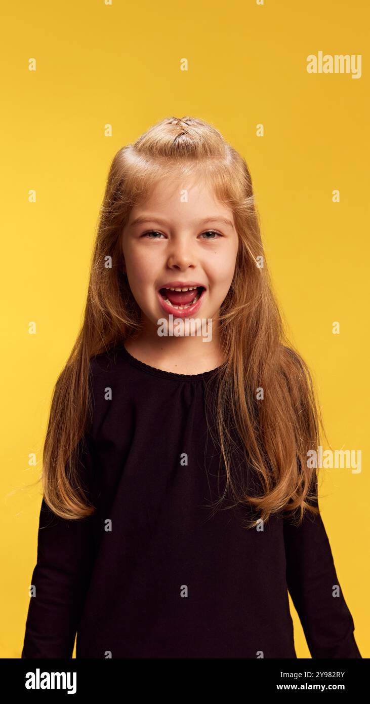 Girl breaks into big, open-mouthed laugh, looking directly at camera ...