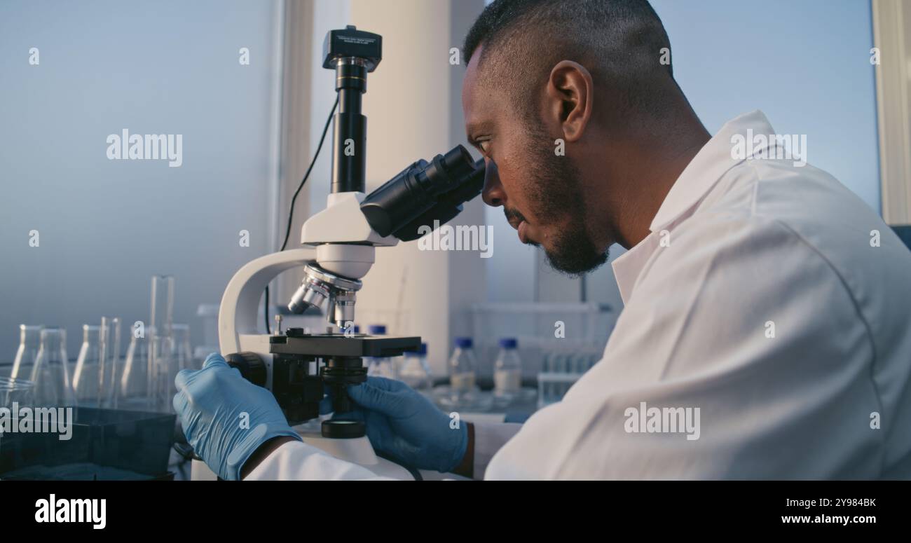 Medical science lab: Dolly shot of African American male microbiologist ...
