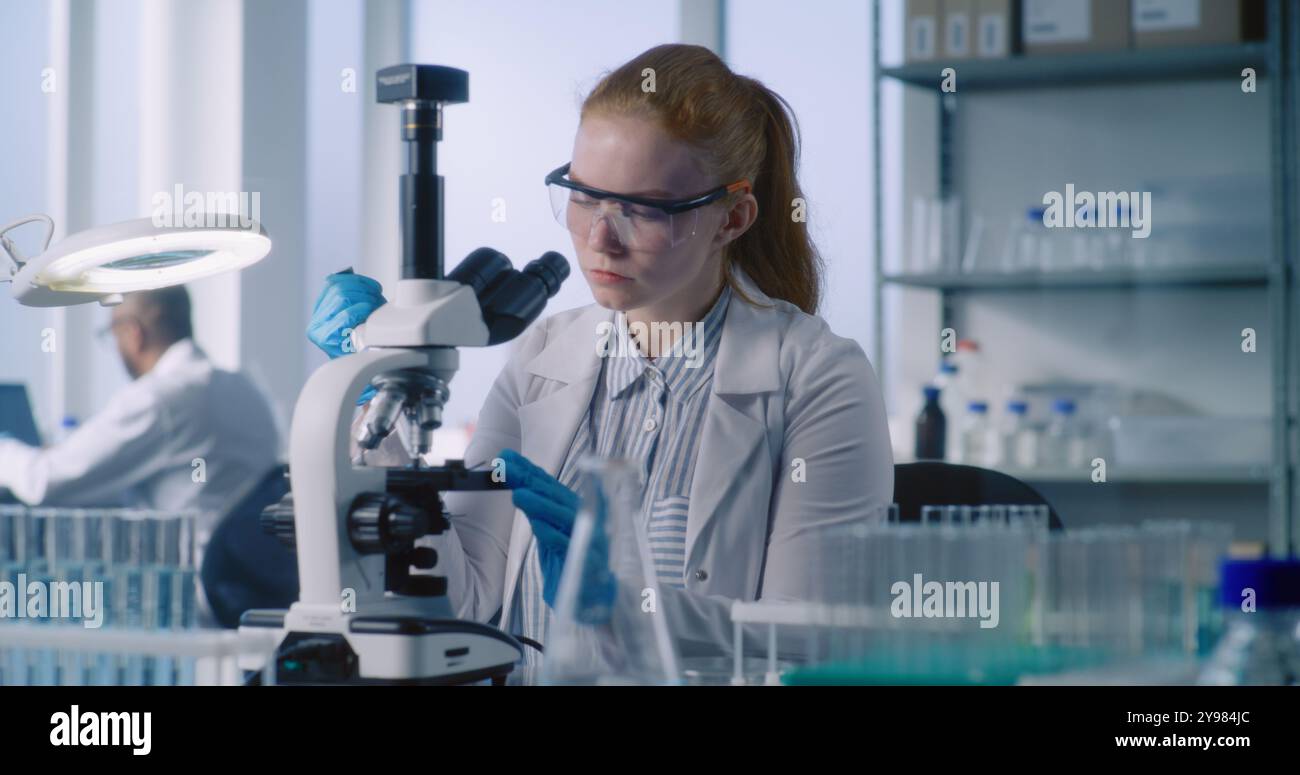 Bright medical science laboratory: Female biochemist takes liquid from ...