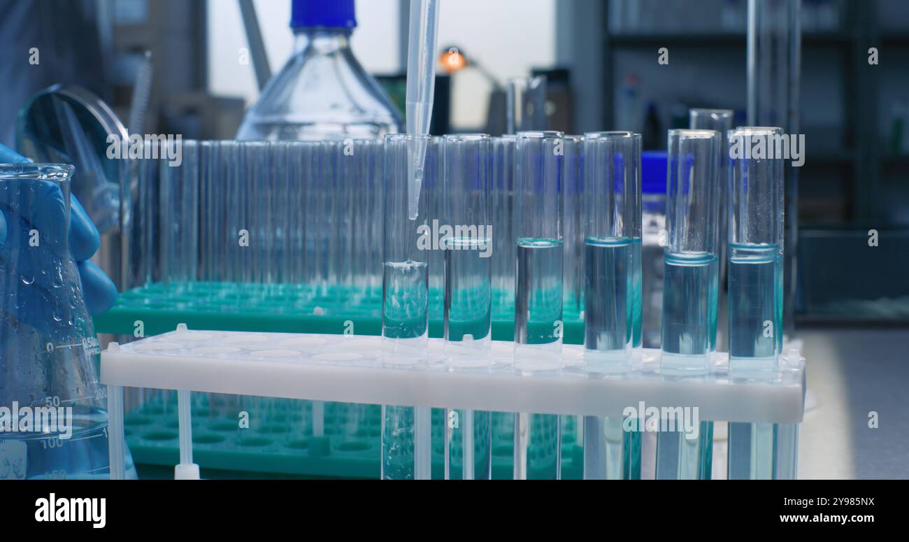 Medical research lab: Close up of scientist taking blue liquid with ...