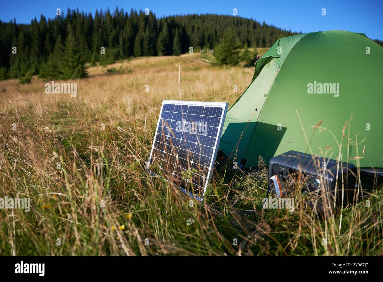 Tourist tent with solar panel and portable power station nearby in ...