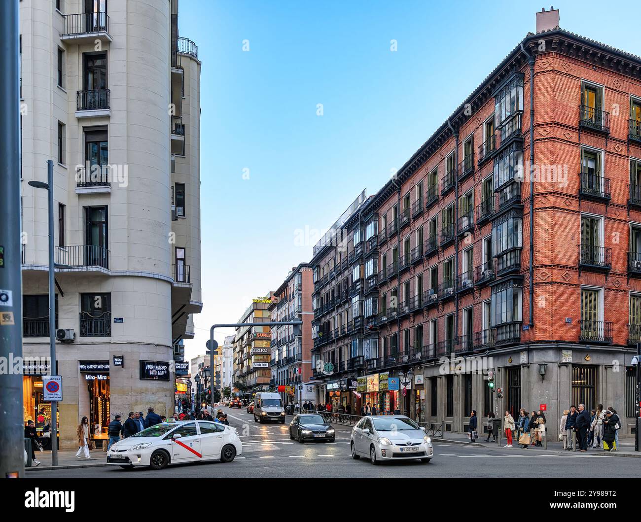 A taxi and other cars driving at an intersection on La Gran Via Stock ...
