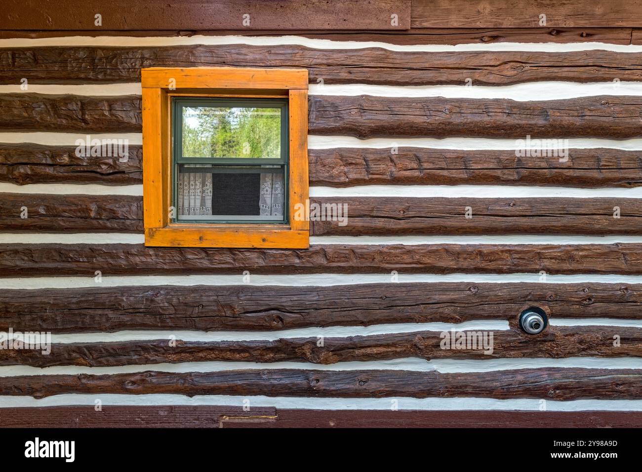 A window and a metal vent in the exterior wall of a log cabin Stock ...