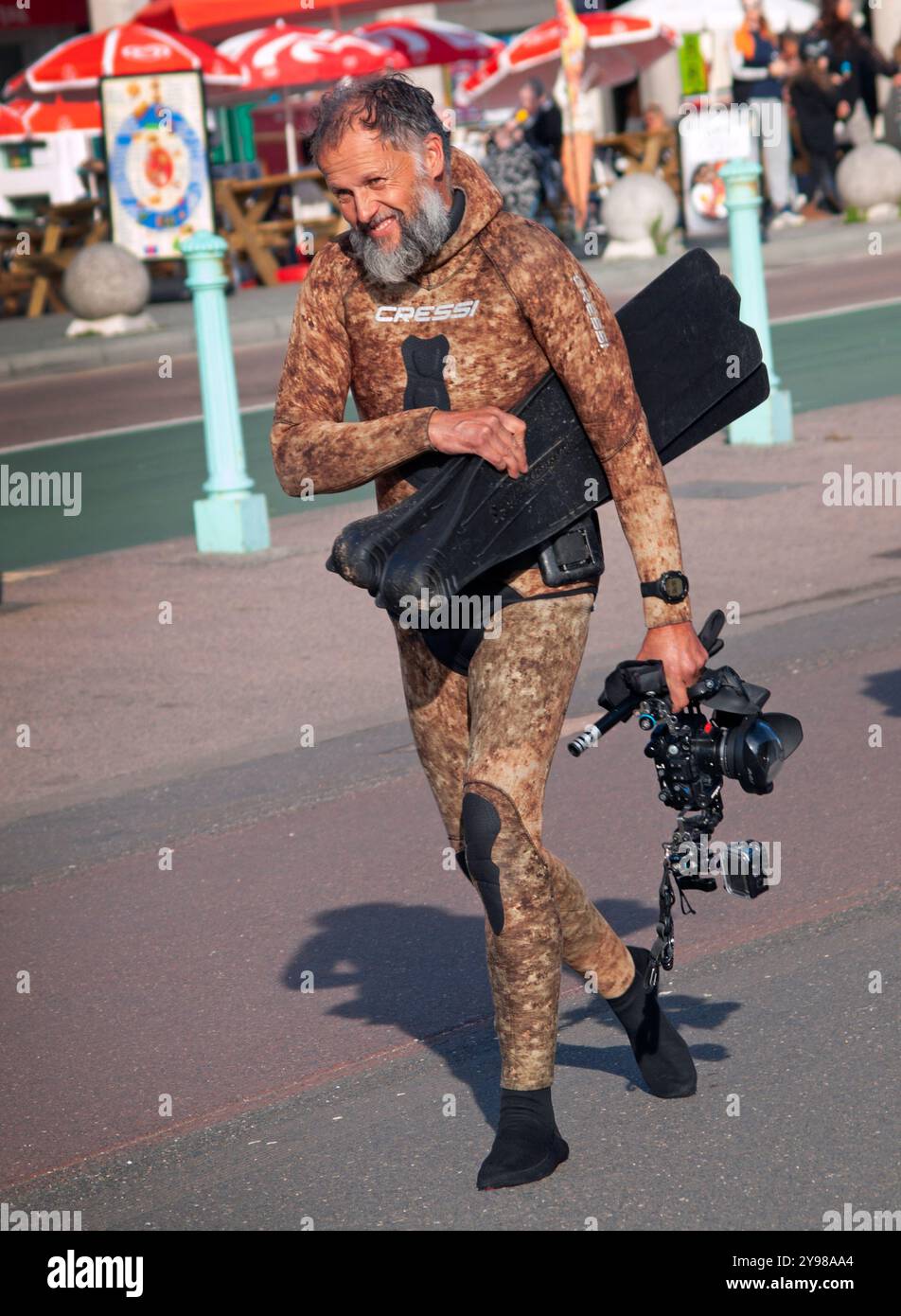 A diver heads towards the sea for a swim in Brighton Stock Photo - Alamy