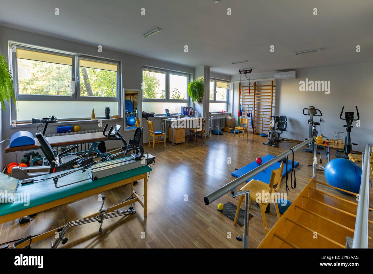 A room with medical equipment for rehabilitation exercises, a treadmill ...