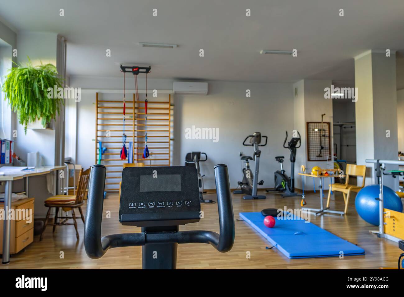 A room with medical equipment for rehabilitation exercises, a treadmill ...