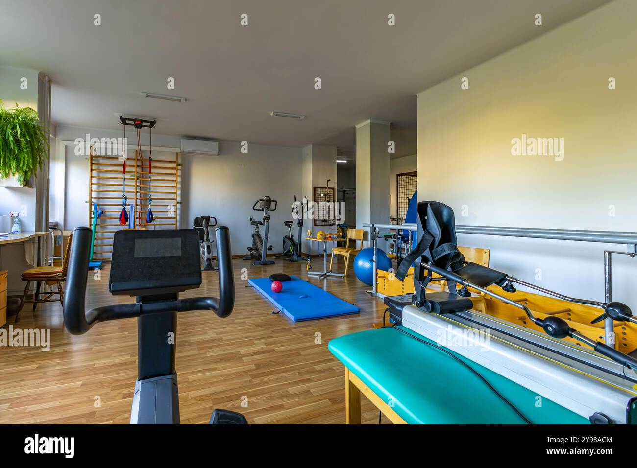 A room with medical equipment for rehabilitation exercises, a treadmill ...