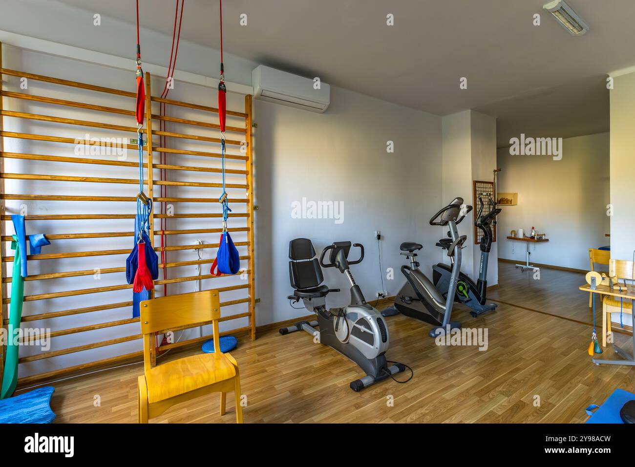 A room with medical equipment for rehabilitation exercises, a treadmill ...