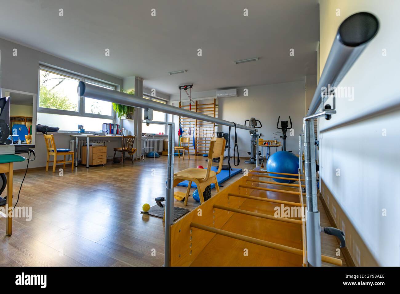 A room with medical equipment for rehabilitation exercises, a treadmill ...