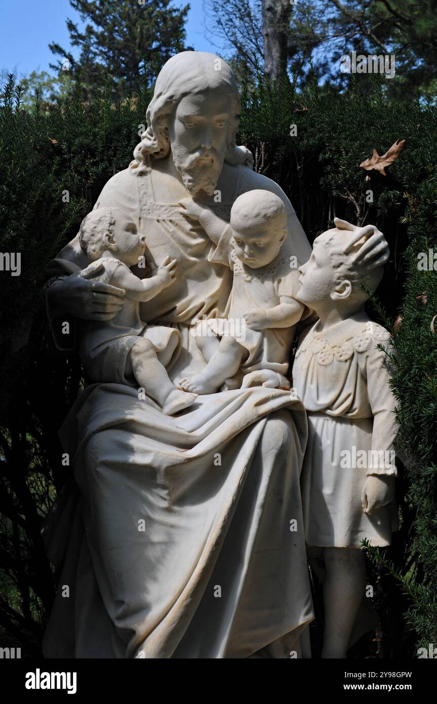 A sculpture of Jesus surrounded by children at a grave in the historic ...