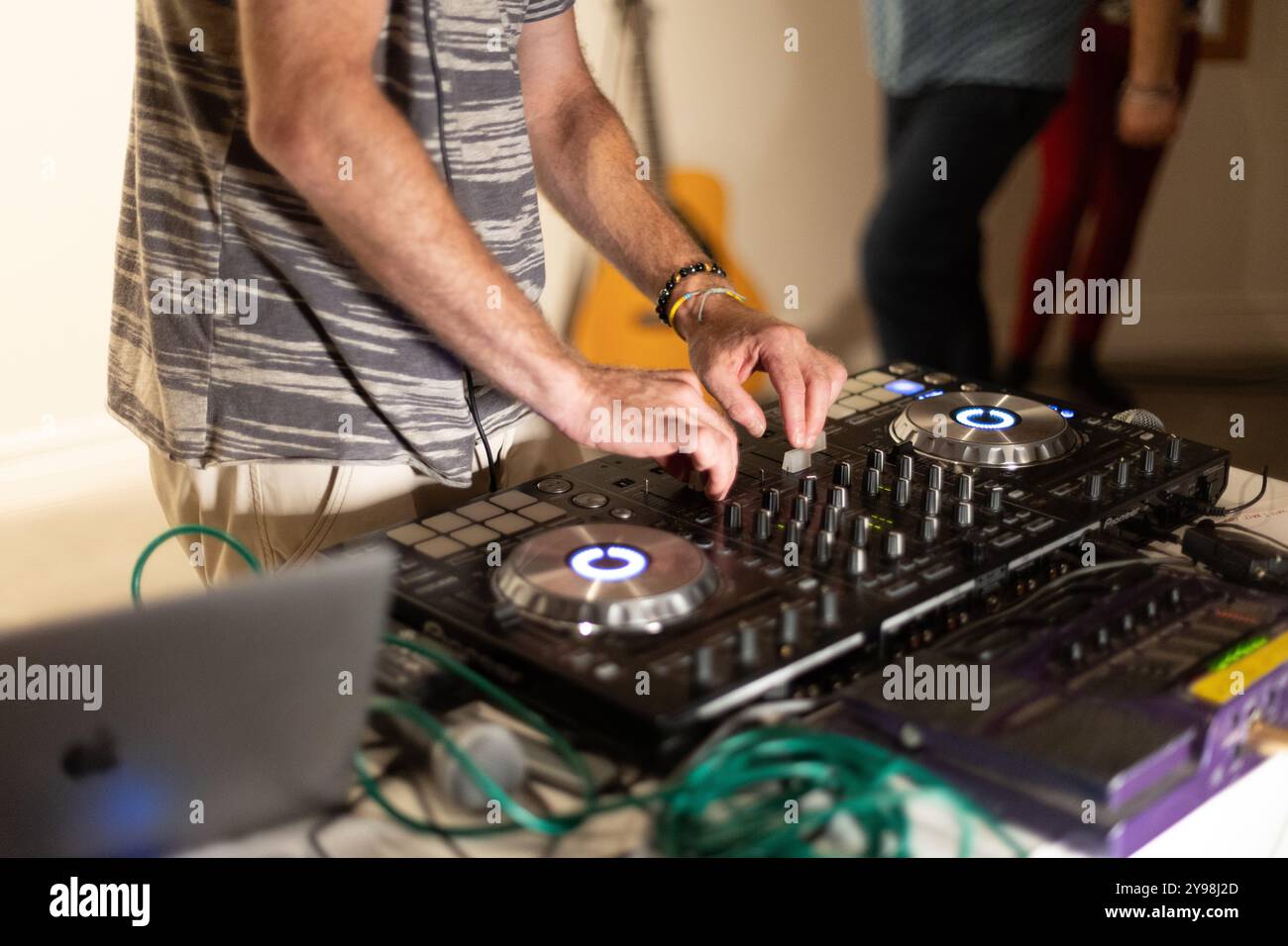 Disc jockey mixing electronic music on a professional dj controller ...