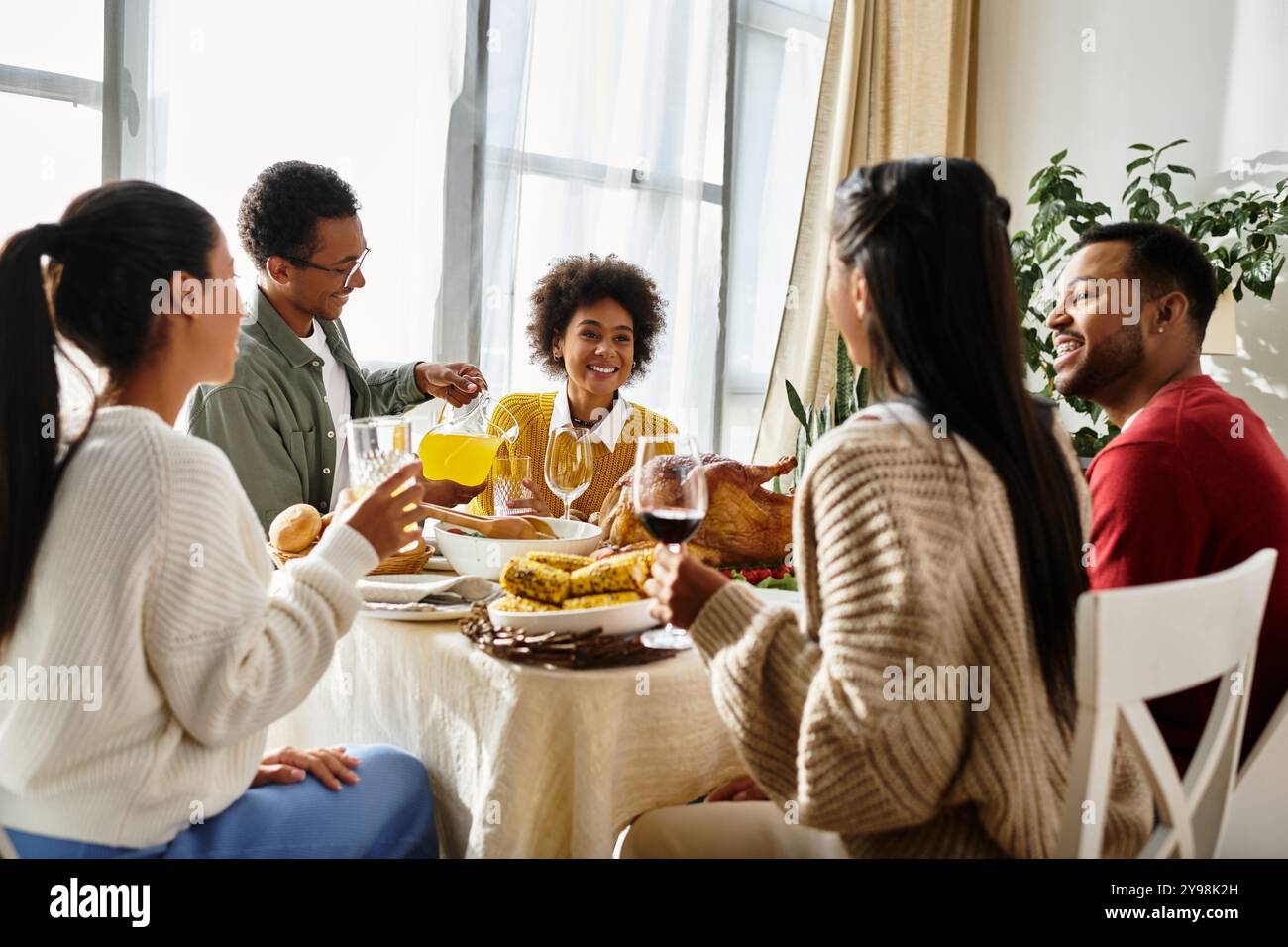 A joyful group of friends gathers around the table, savoring ...