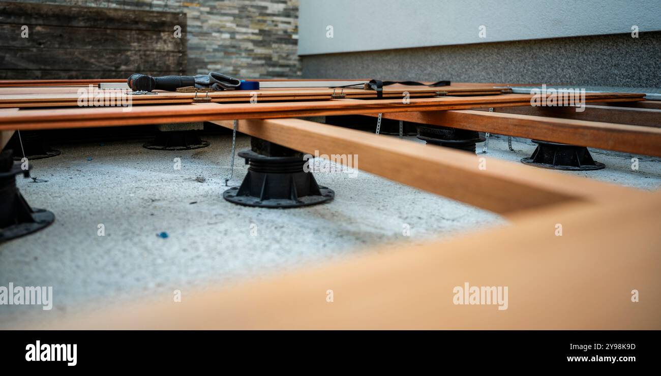 A focused shot of wooden beams supported by adjustable pedestals during ...