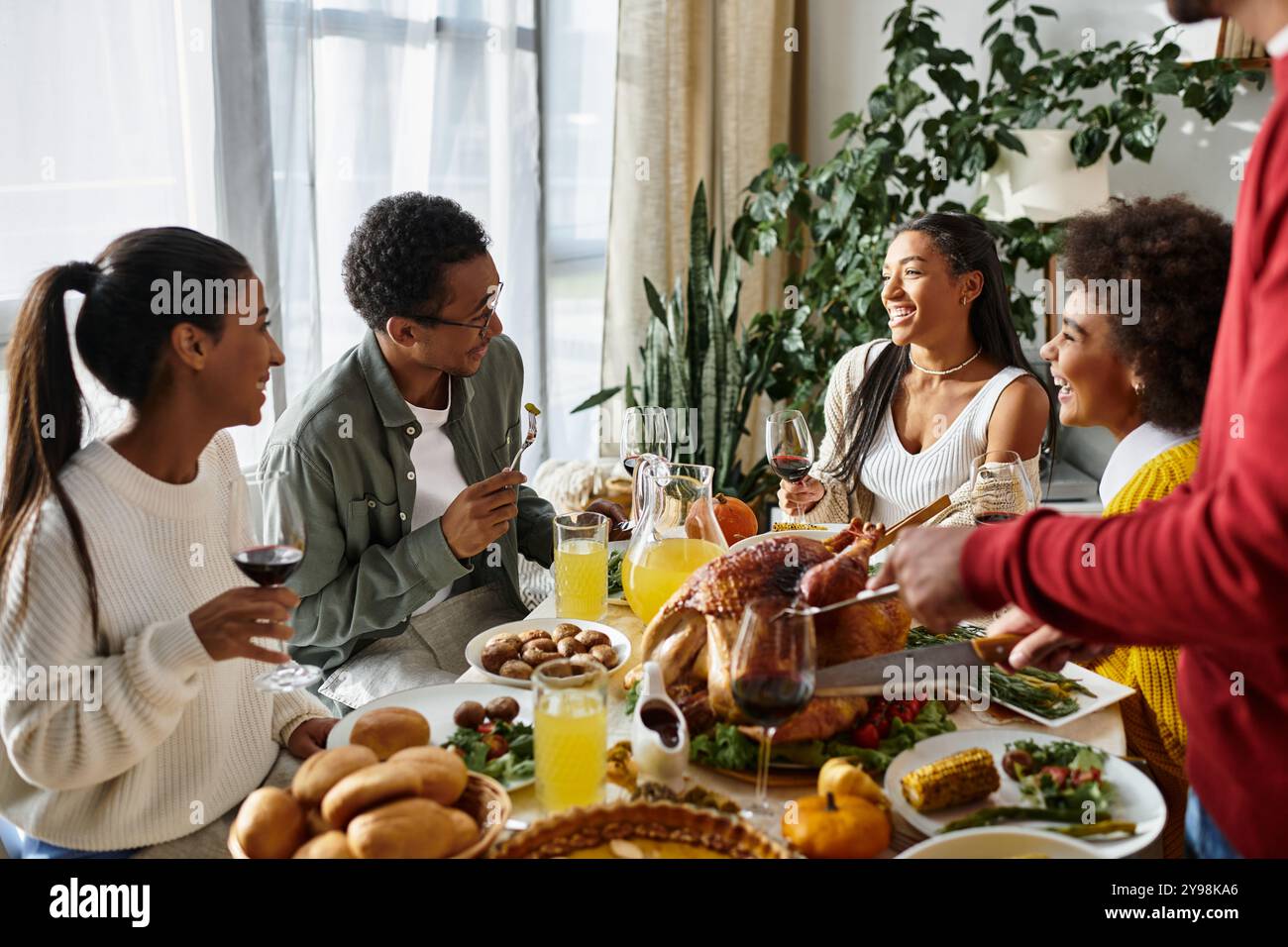 A lively group of friends shares laughter and gratitude at a festive ...
