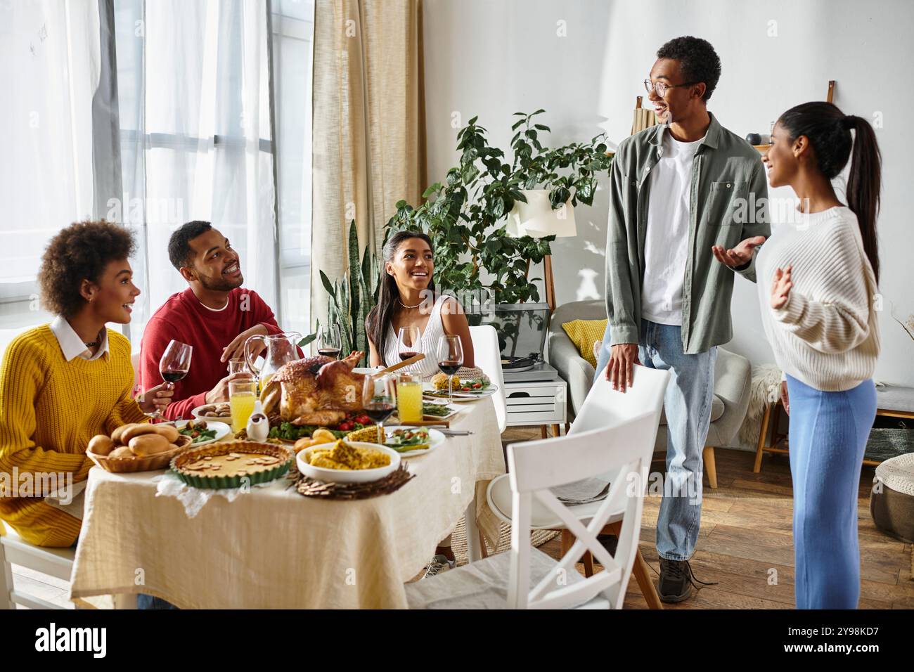 A group of friends enjoys Thanksgiving together, sharing stories and ...