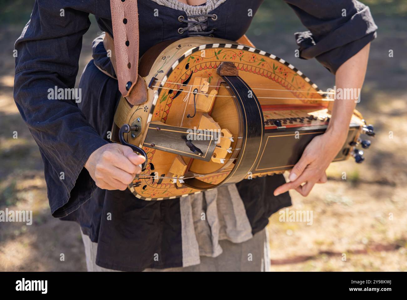 Musician is playing a hurdy gurdy, a stringed musical instrument that ...