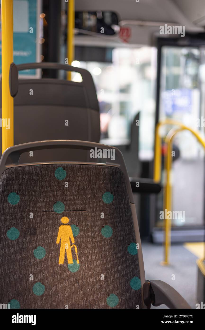 The interior of a city bus shows rows of seats with clear markings for ...