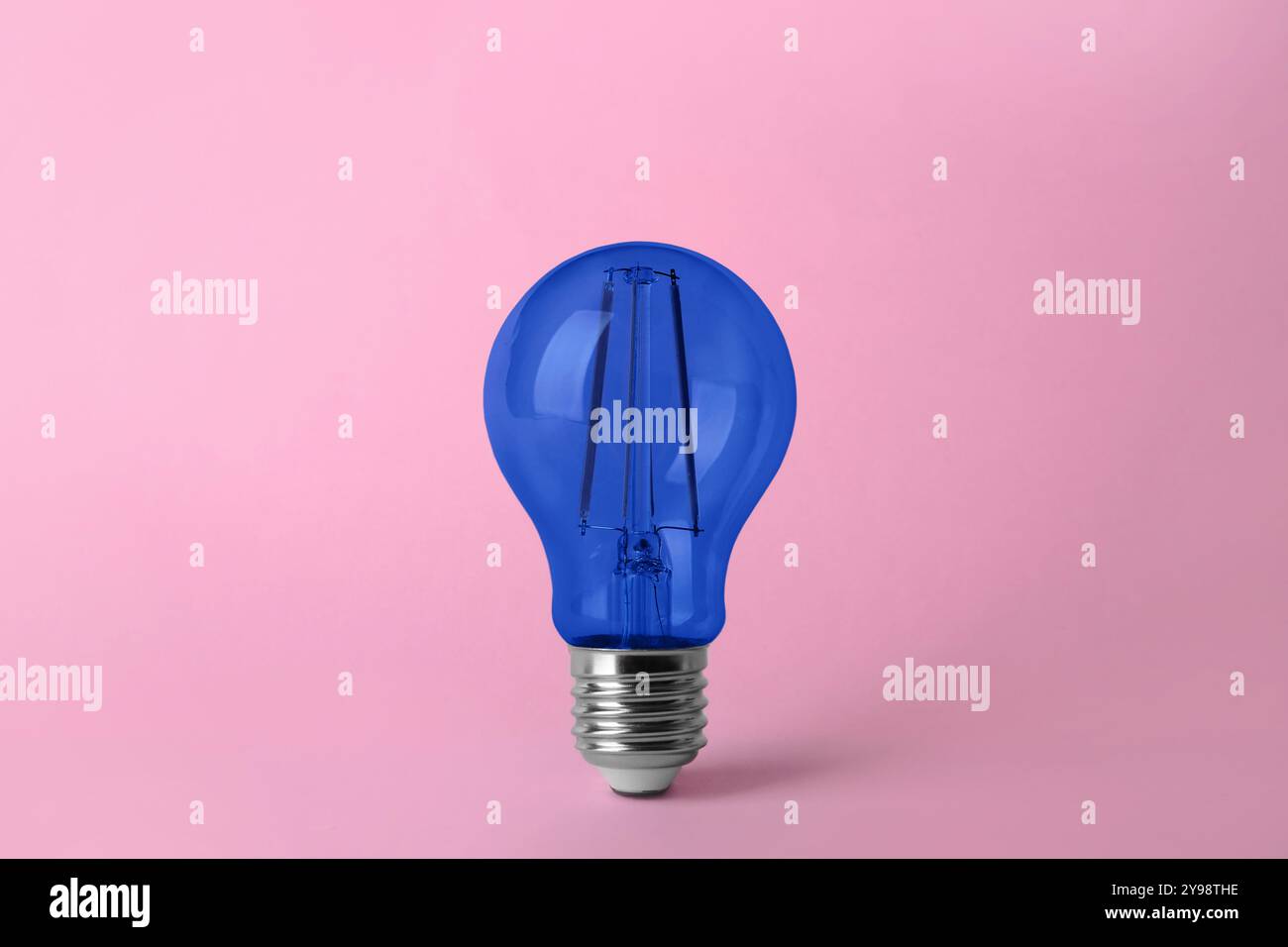 One blue light bulb on pink background Stock Photo - Alamy