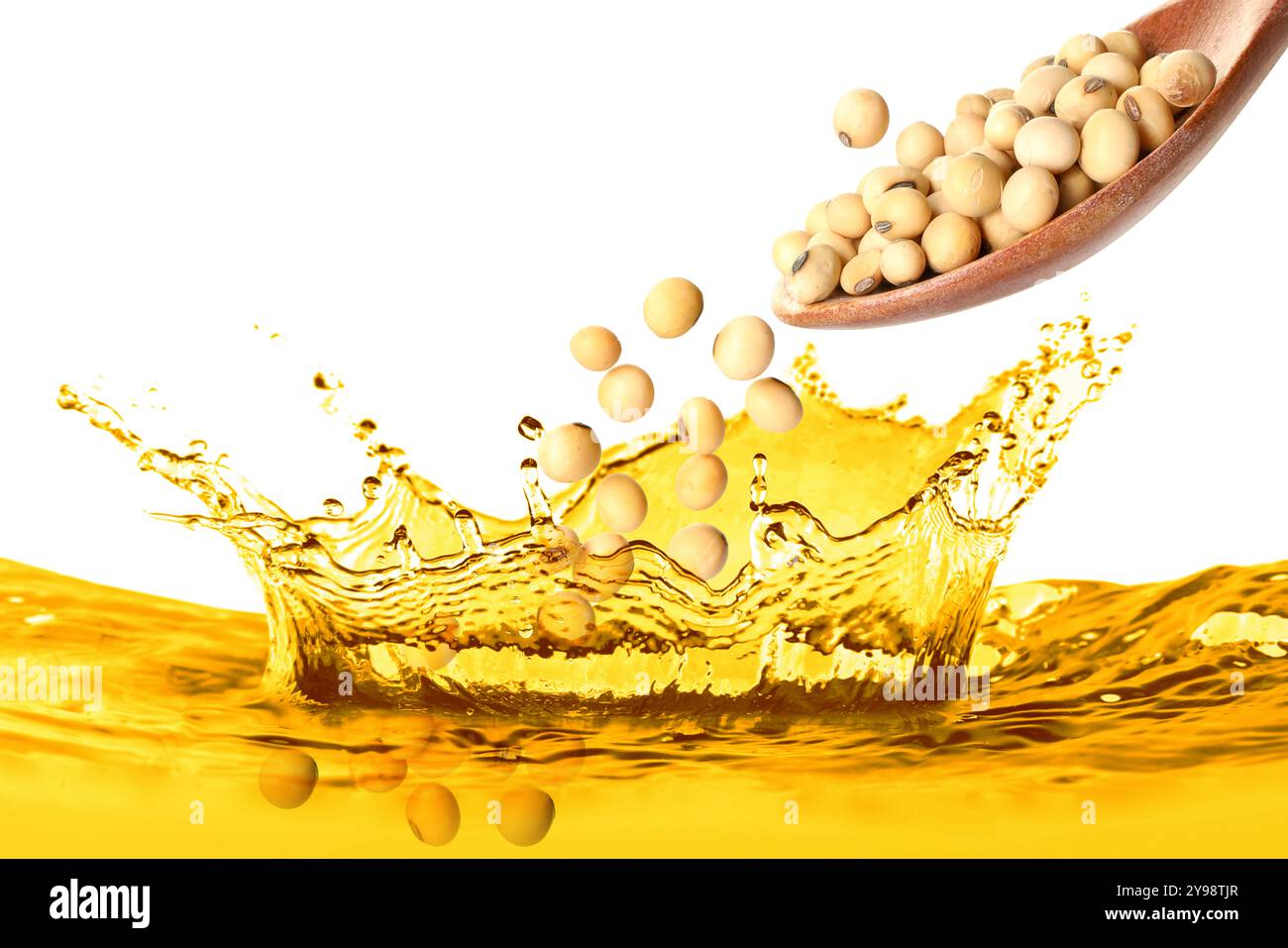 Soy beans falling from wooden spoon into vegetable oil on white ... Soy beans falling from wooden spoon into vegetable oil on white ...