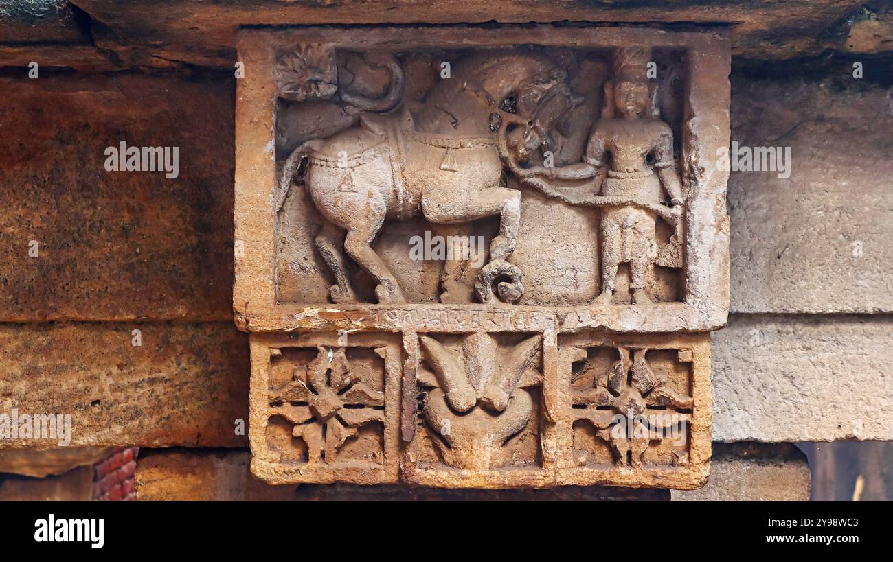 Carving of a man holding a horse and mythical creature on the lower ...